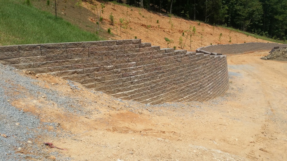 Retaining Wall Installed To Stabilize Hillside Above Driveway